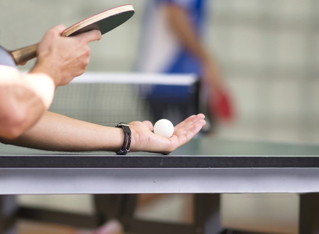 table tennis player serving, focus at the ball, small depth of field ...